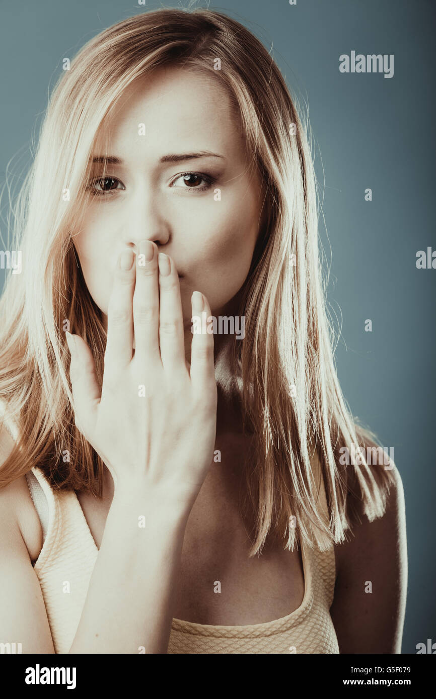 Speak no evil concept. Surprised woman face covering her mouth with ...