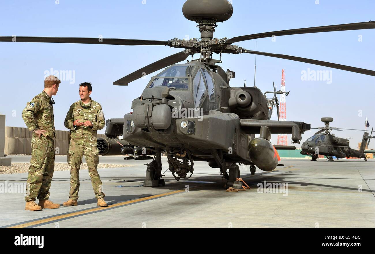 Prince Harry is shown the Apache flight-line by a member of his ...