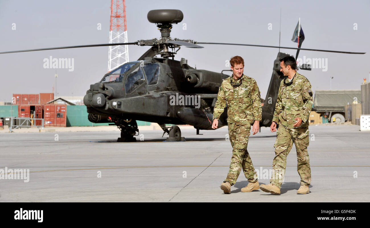 Prince Harry is shown the Apache flight-line by a member of his ...