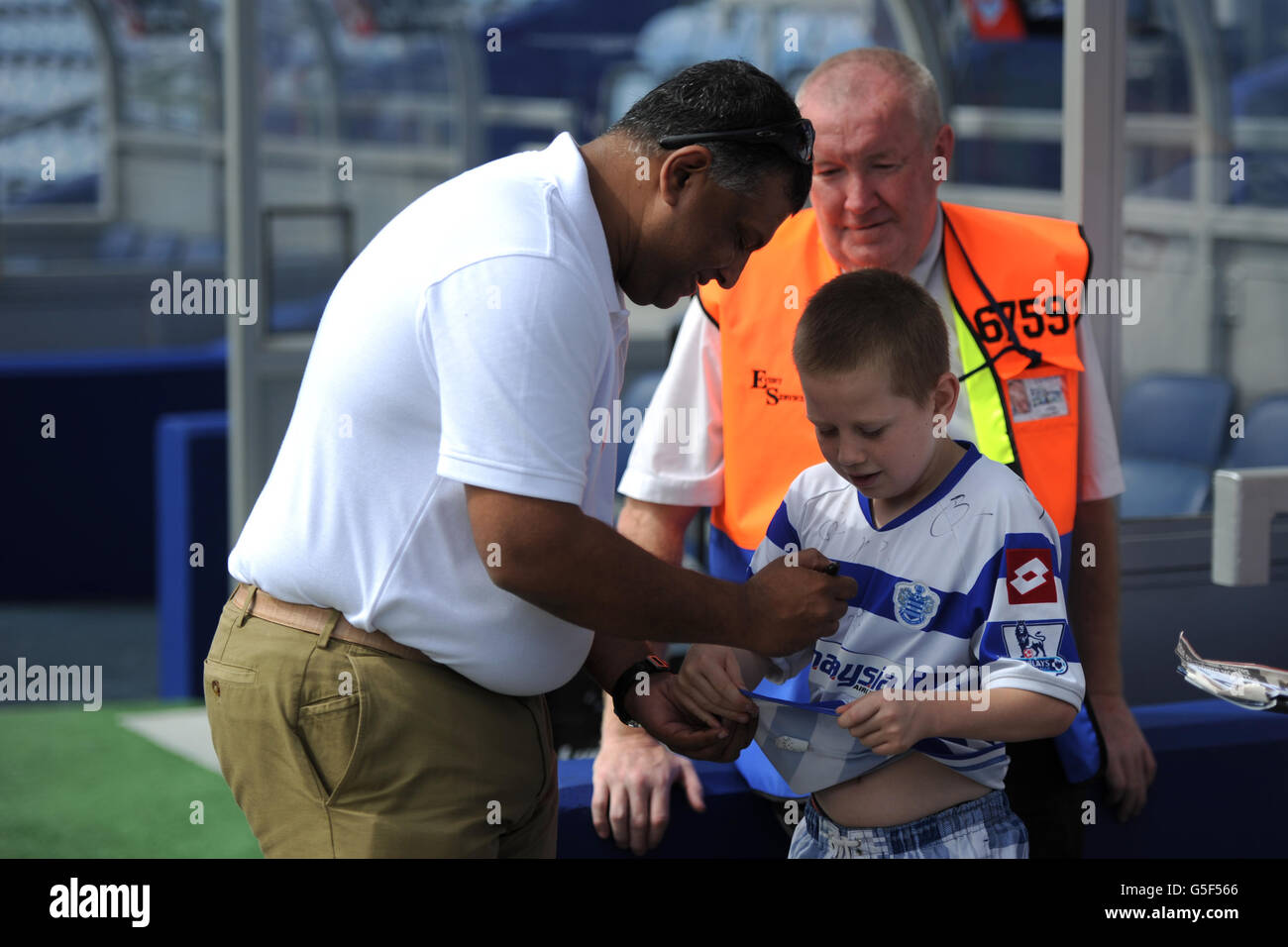 Queens Park Rangers Chairman Tony Fernandes (left) signs autographs for ...