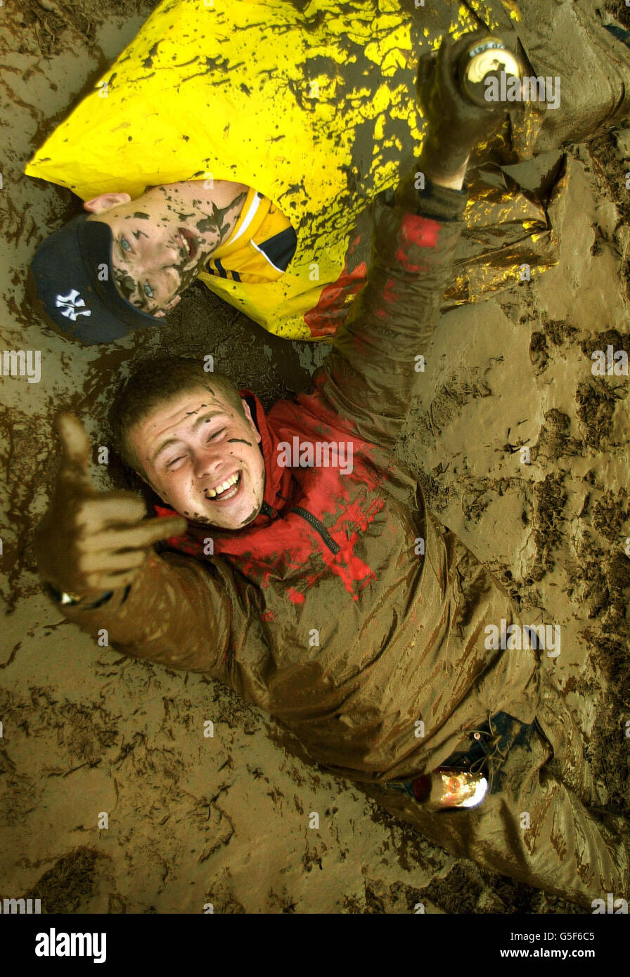 Fans appear oblivious as they lie in the mud caused by heavy rains at ...