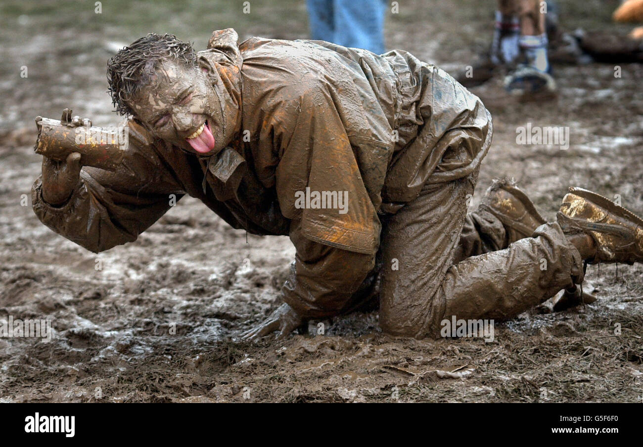 A fan slides in the mud at the T in the Park music festival near ...