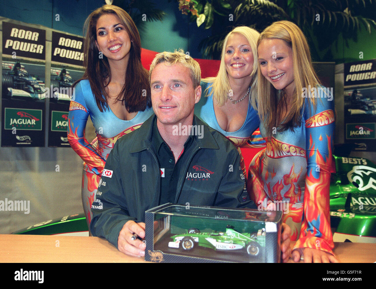 Models surround f1 hero eddie irvine as he promotes hi-res stock ...