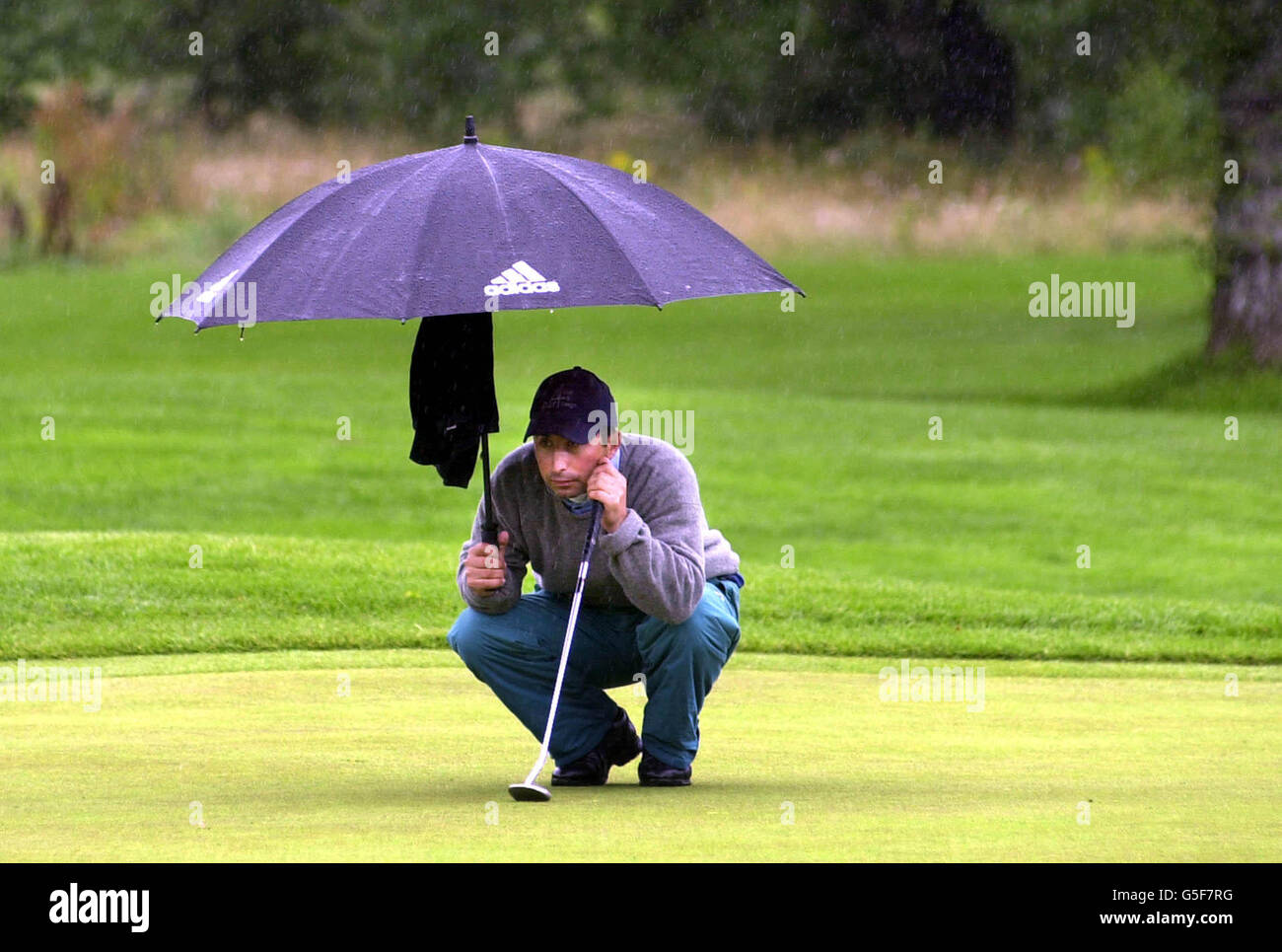 Germany's Erol Simsek shelters from the heavy rain during the Scottish ...