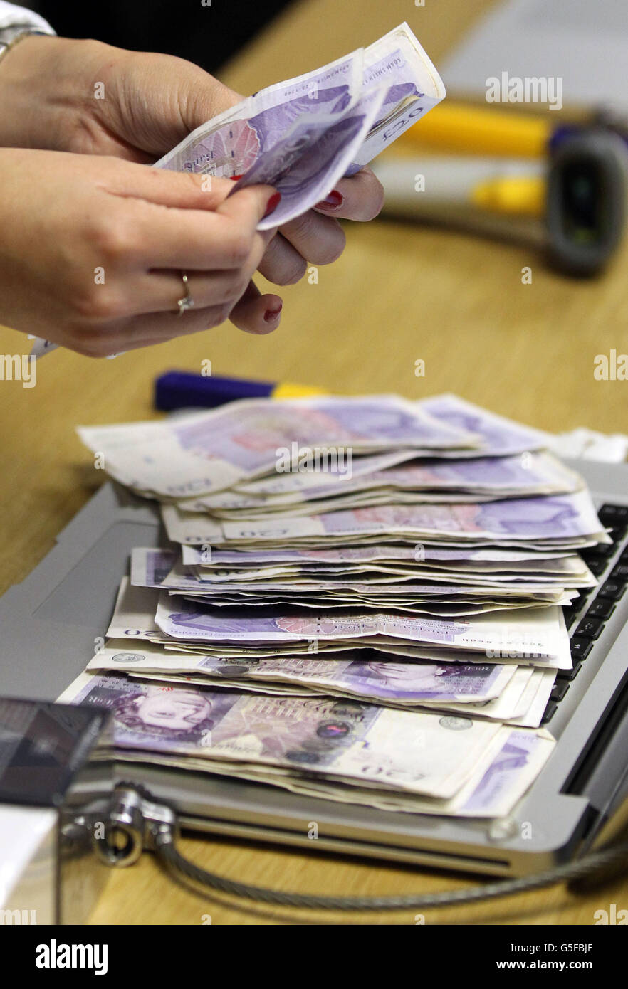 Apple workers count money as a customer buys the new iPhone 5 at the ...