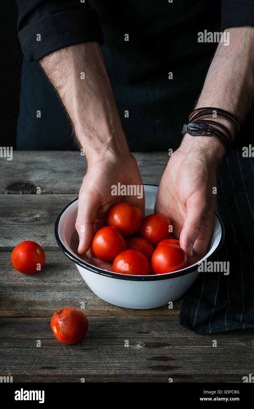 Male chef washing tomatoes. Tomatoes in hands Stock Photo - Alamy