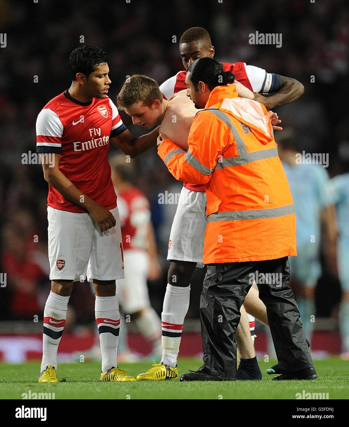 A pitch invader is taken off the pitch during the Capital One Cup ...