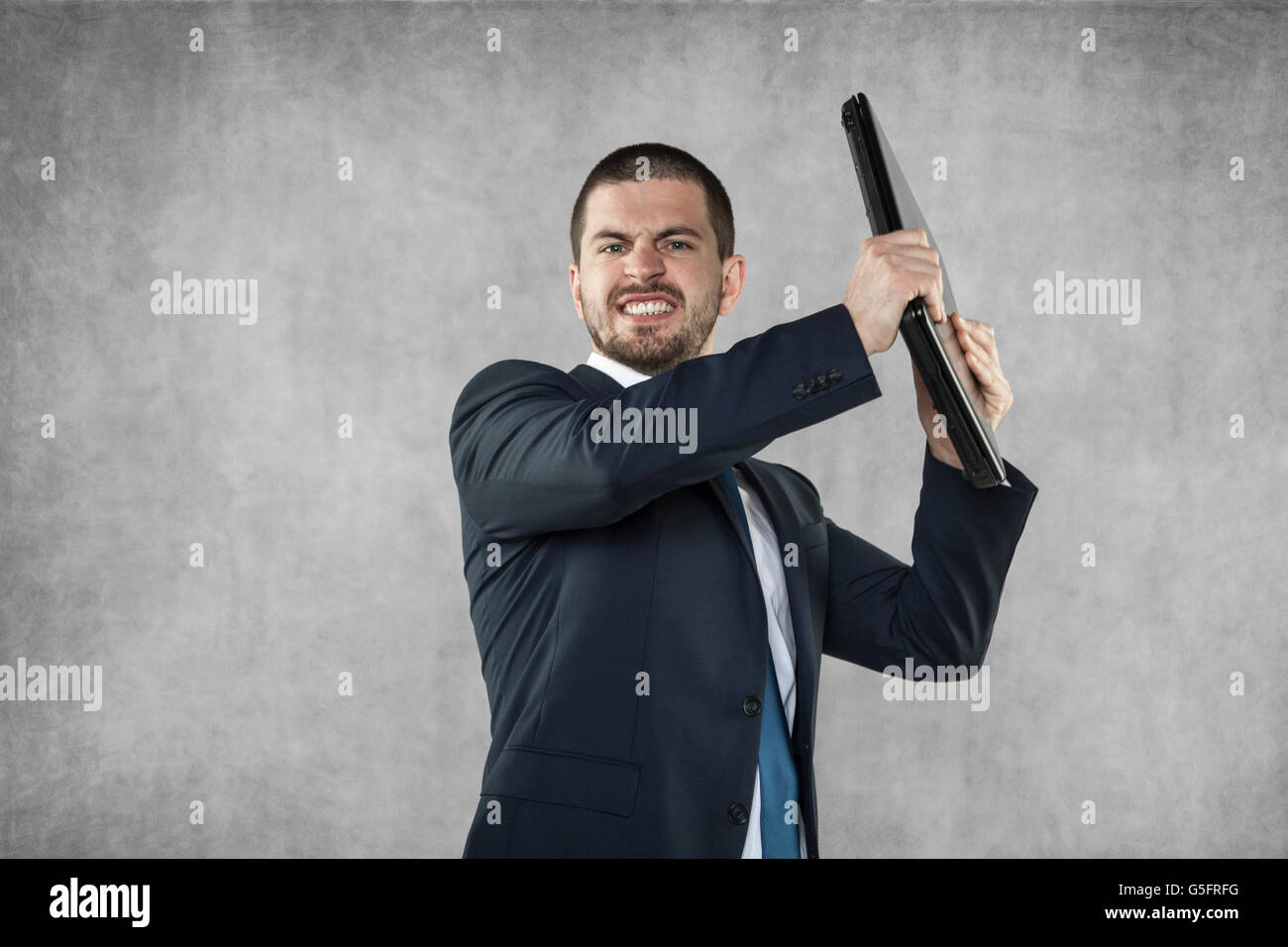 Angry businessman destroying computer Stock Photo - Alamy