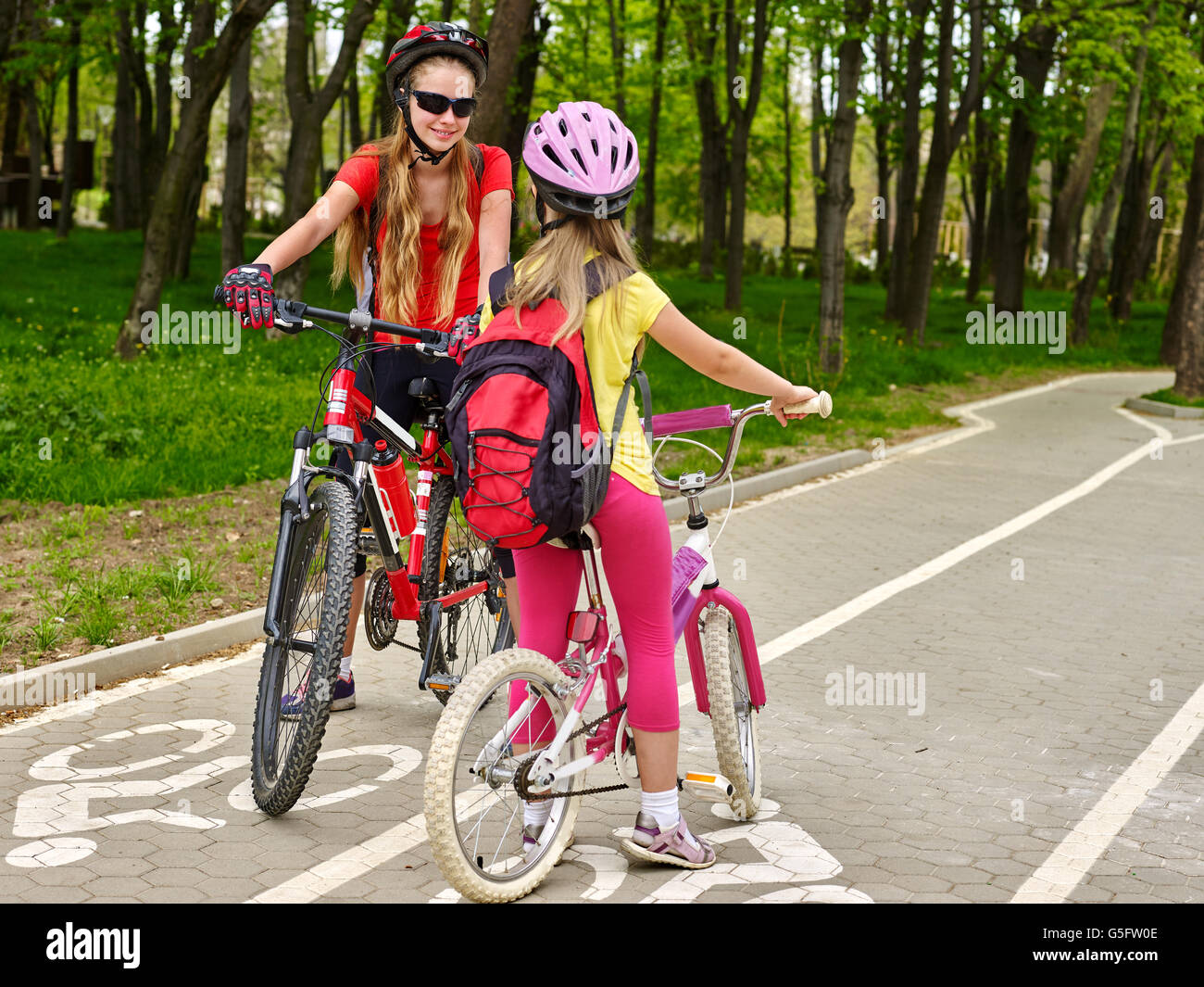 Girls children cycling on yellow bike lane Stock Photo - Alamy