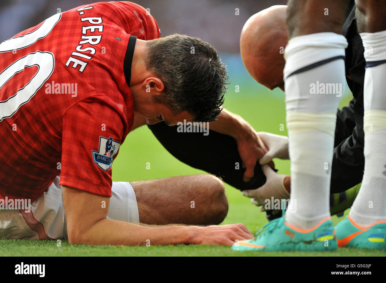 Manchester uniteds robin van persie feels his injured leg hi-res stock ...
