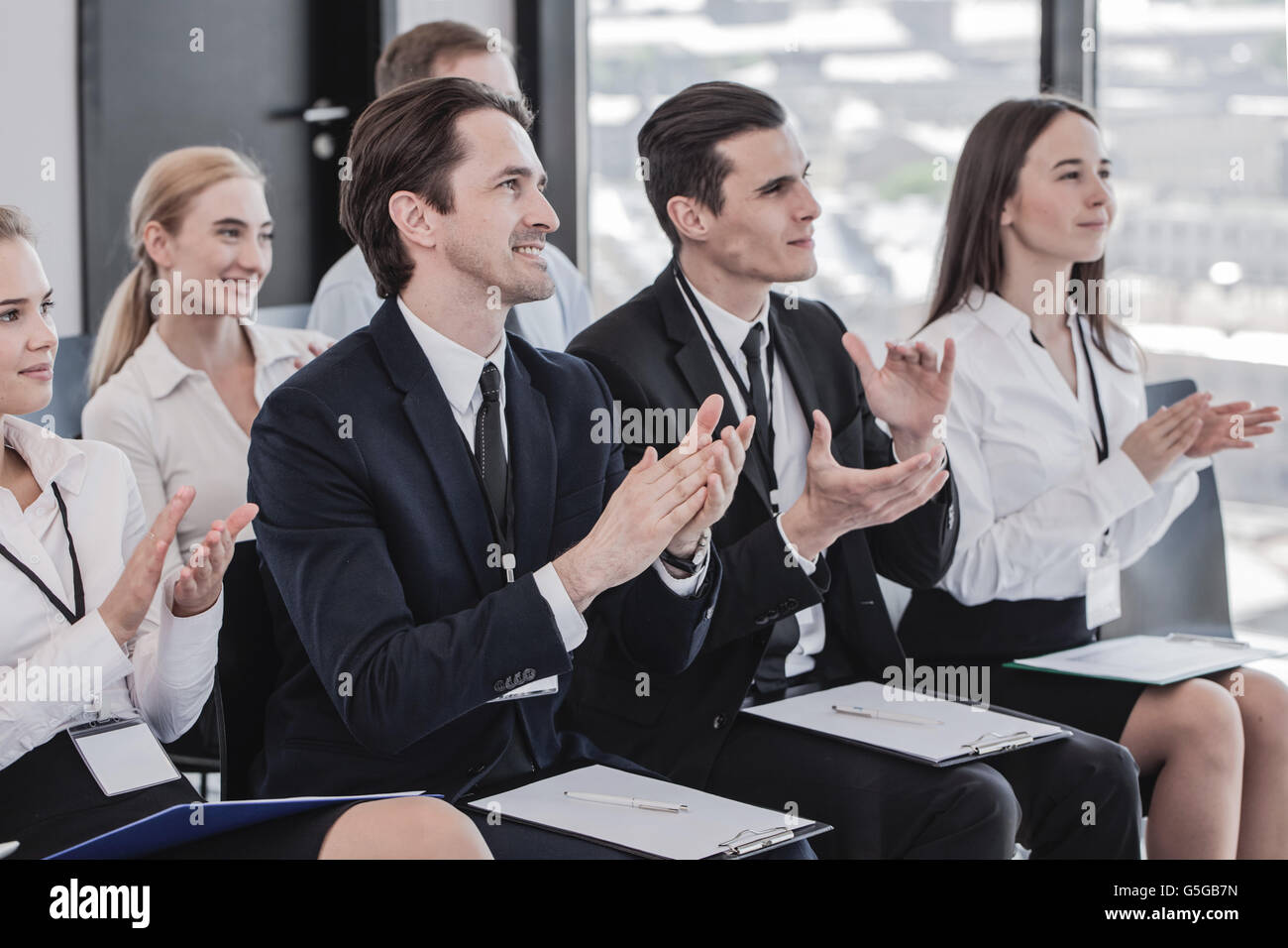Happy business group of people clapping hands during a meeting ...