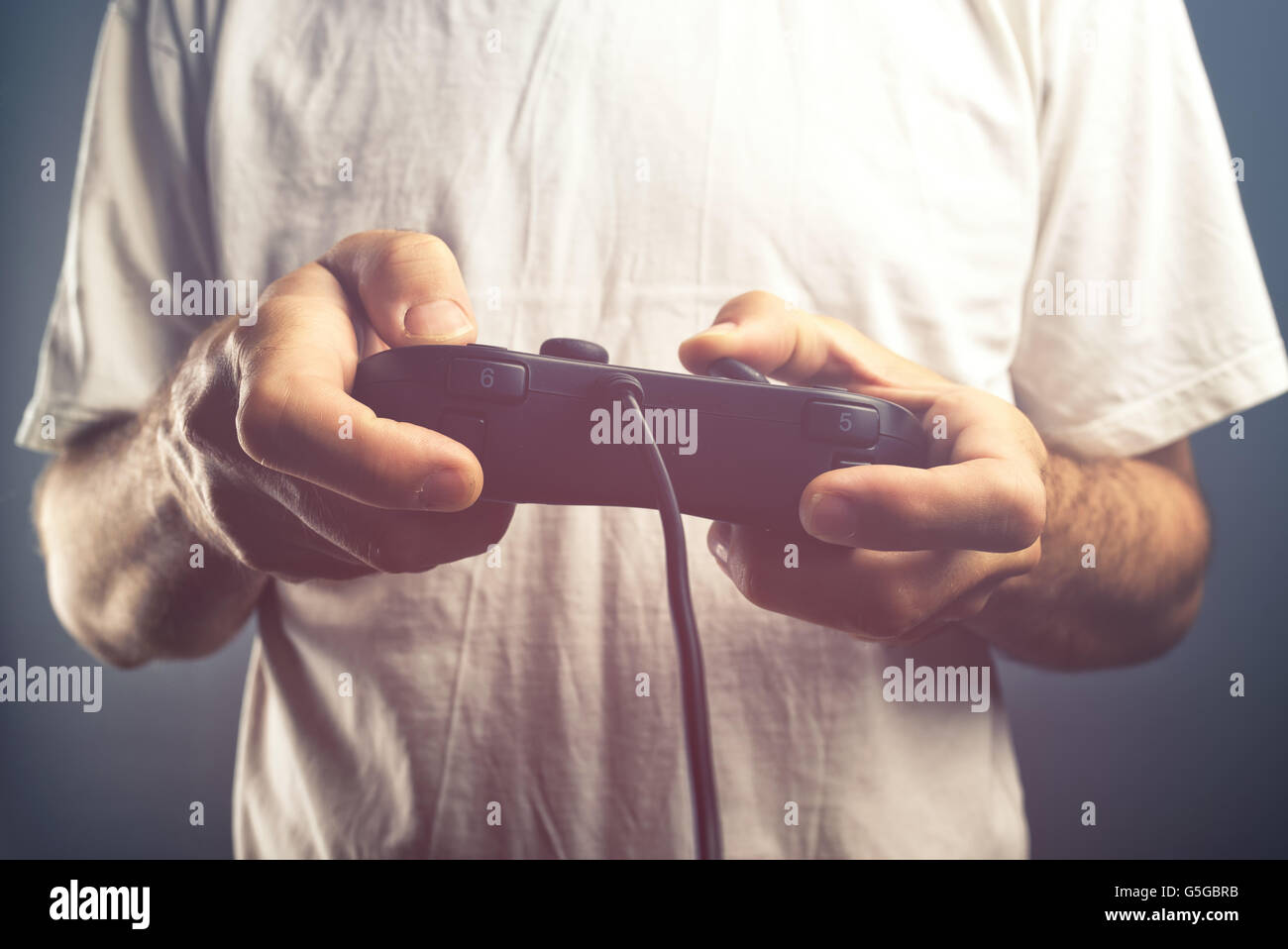 Man using game pad controller to play entertaining electronics video ...