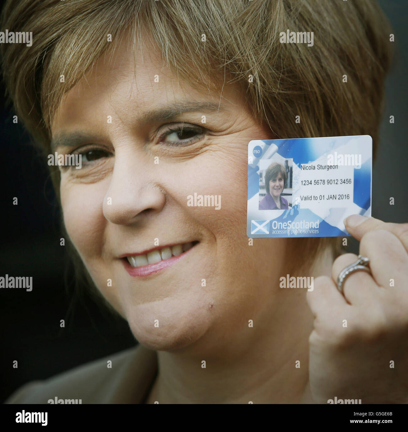 Deputy First Minister Nicola Sturgeon holds up the new Scotland-wide ...