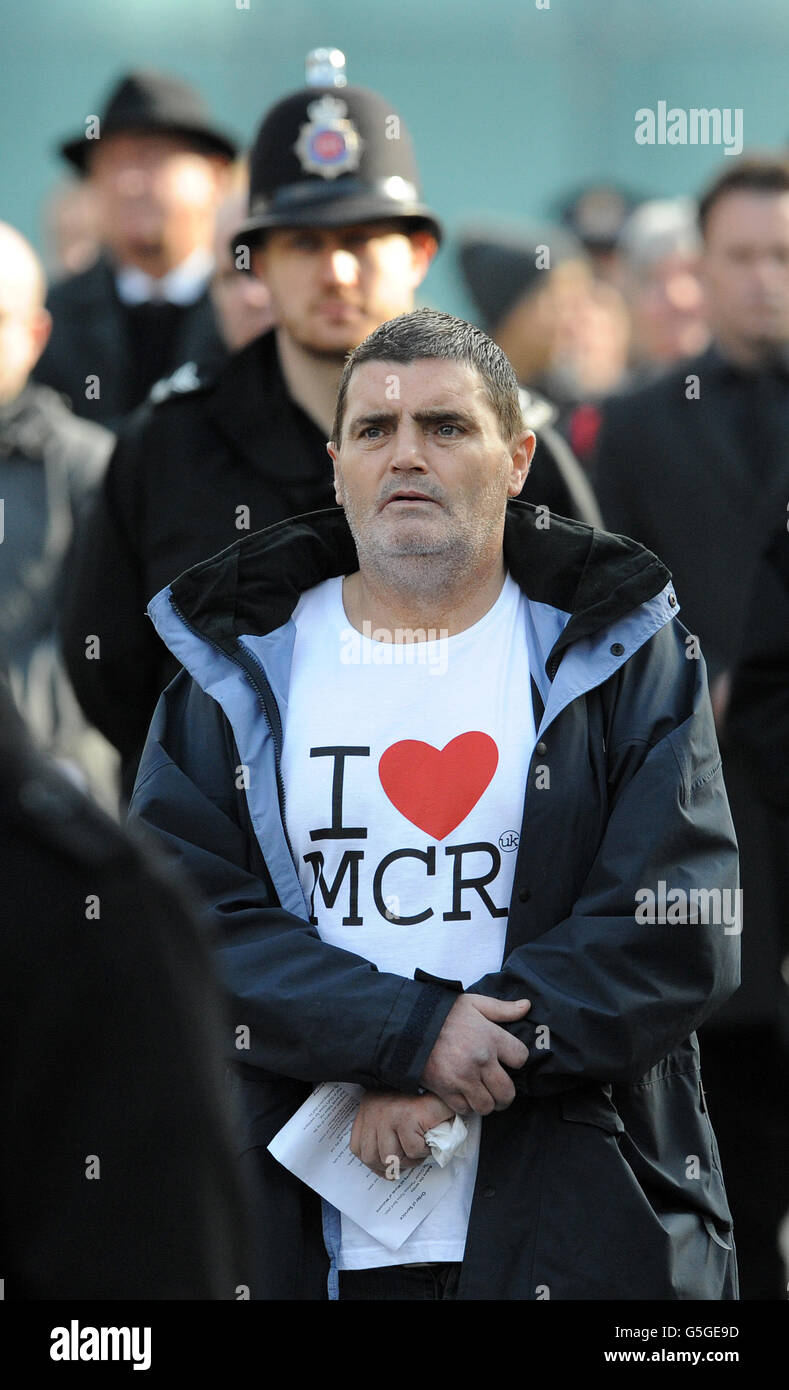 Members of the public stand with police officers at the funeral of PC ...