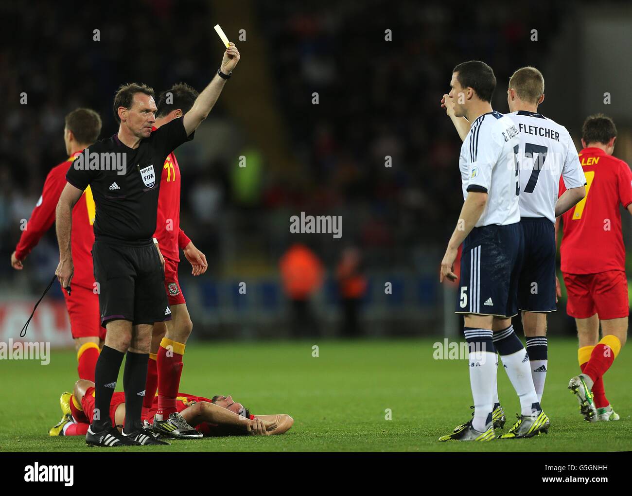 Scotland's Gary Caldwell is shown the yellow card by referee Florian ...