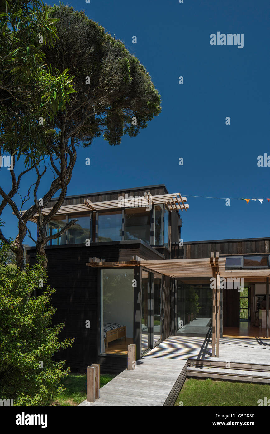 Shot of house from garden with blue sky and endemic tree. PEKA PEKA II ...