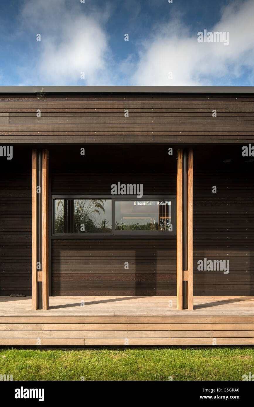 Wooden house entrance with slatted wooden shade. blue sky. decking ...