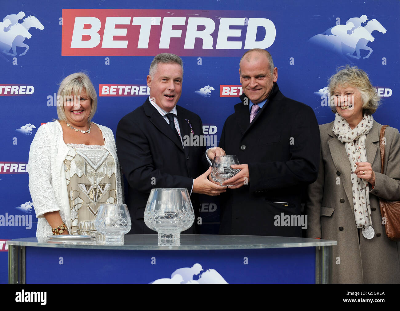 Trainer Brian Meehan (second right) is presented with a trophy after ...