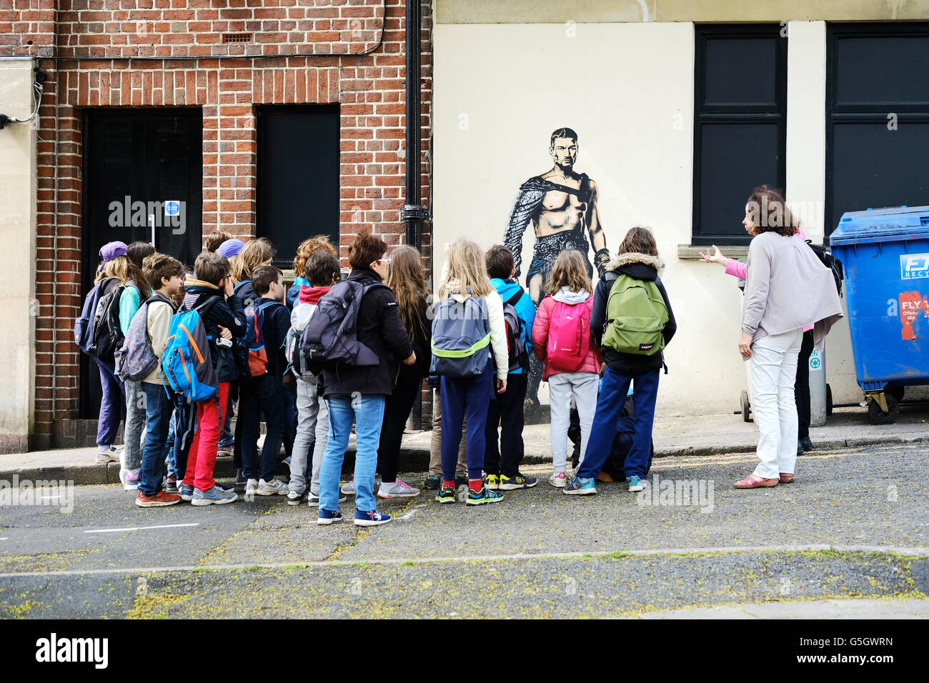 A group of school children being shown graffiti in a city street Stock ...