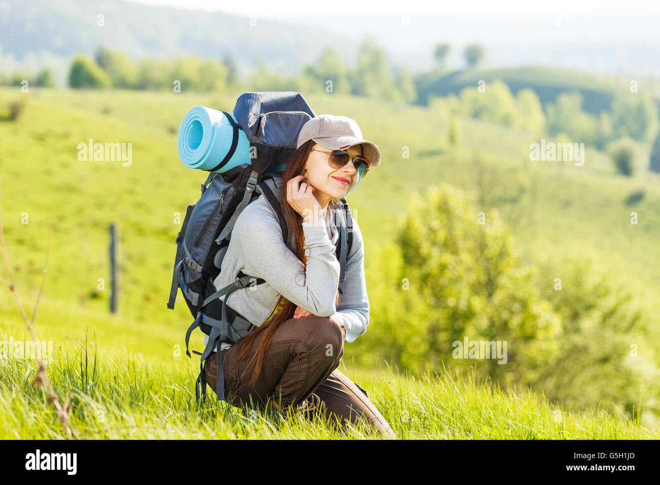 Young backpacking woman rest at the hill. Smiling girl with backpack ...