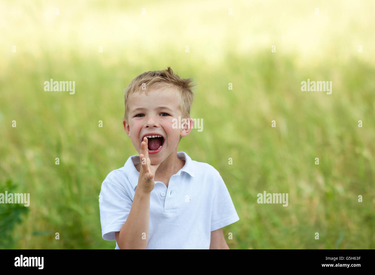 Portrait of young boy shouting loudly on summer day Stock Photo - Alamy
