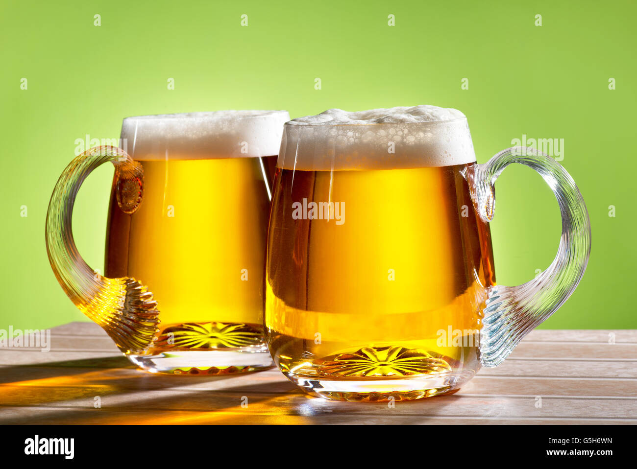 two beers on the table with green background Stock Photo - Alamy