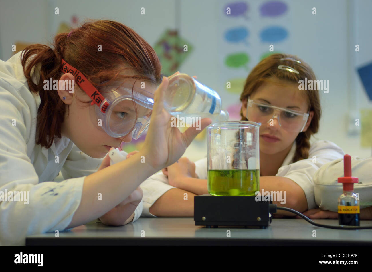 Two female students conducting a science experiment in the classroom ...