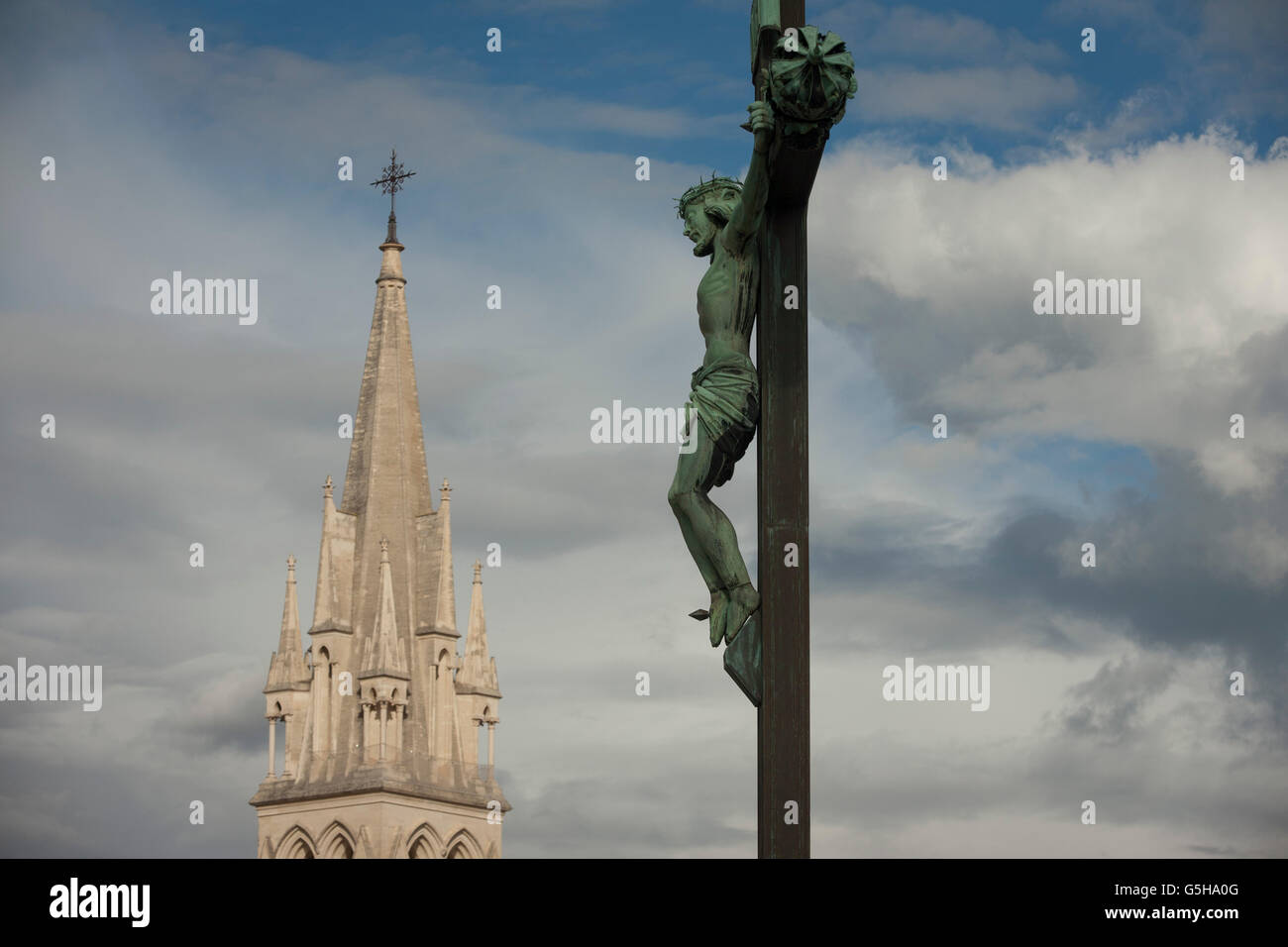 A crucified Christ on the cross looking down on the tall spire of ...