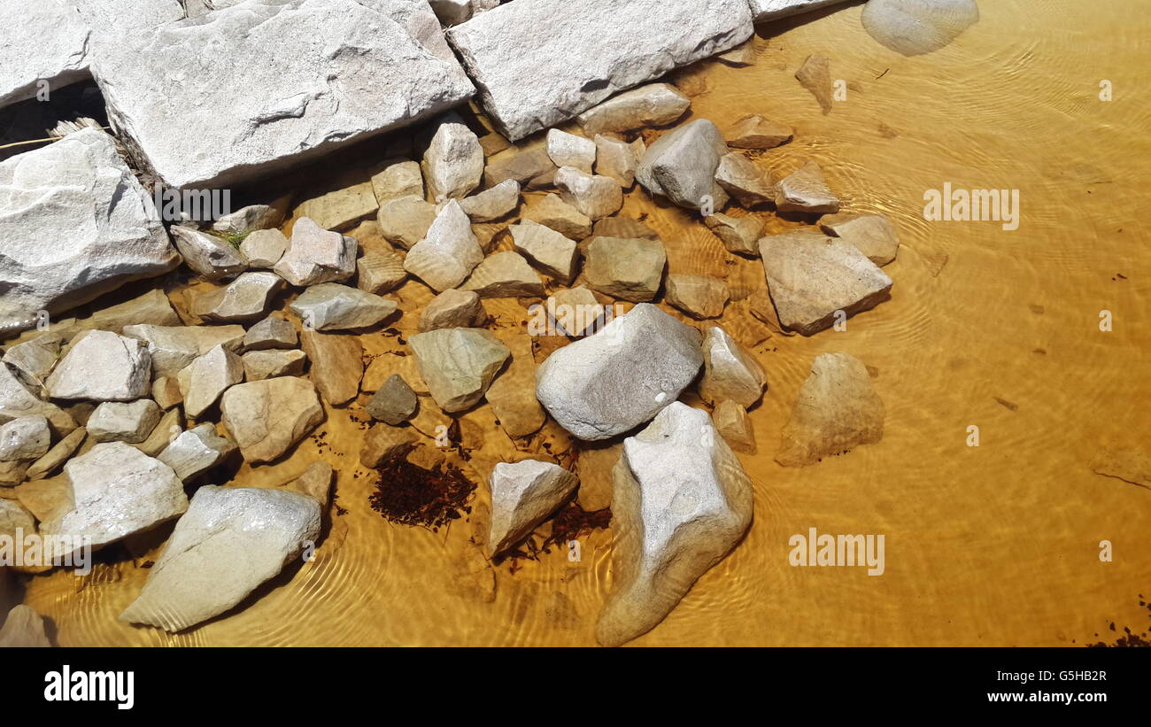 Yellow Water and Stone Stock Photo - Alamy