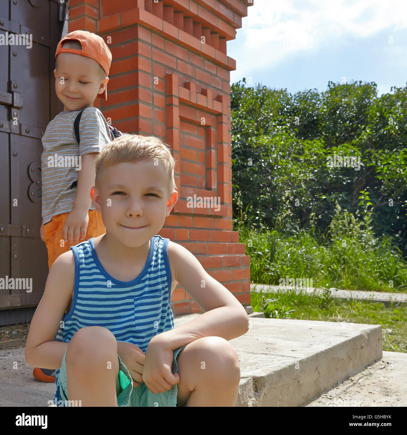 Two little brothers sitting in the summer park Stock Photo - Alamy