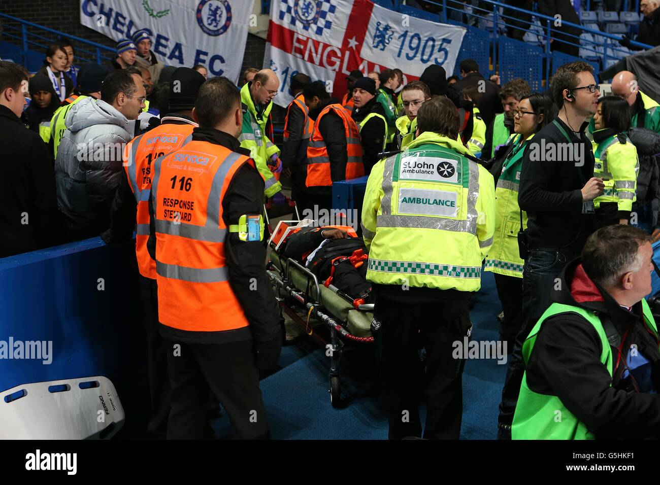 A Chelsea steward is stretchered away from the pitch area after an ...