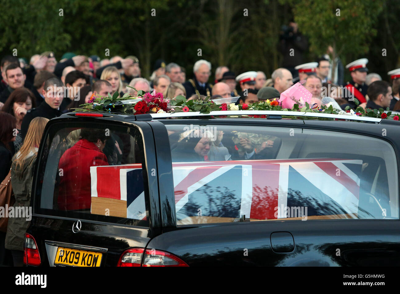 Mourners lay flowers on the hearse carrying Corporal Channing Day from ...