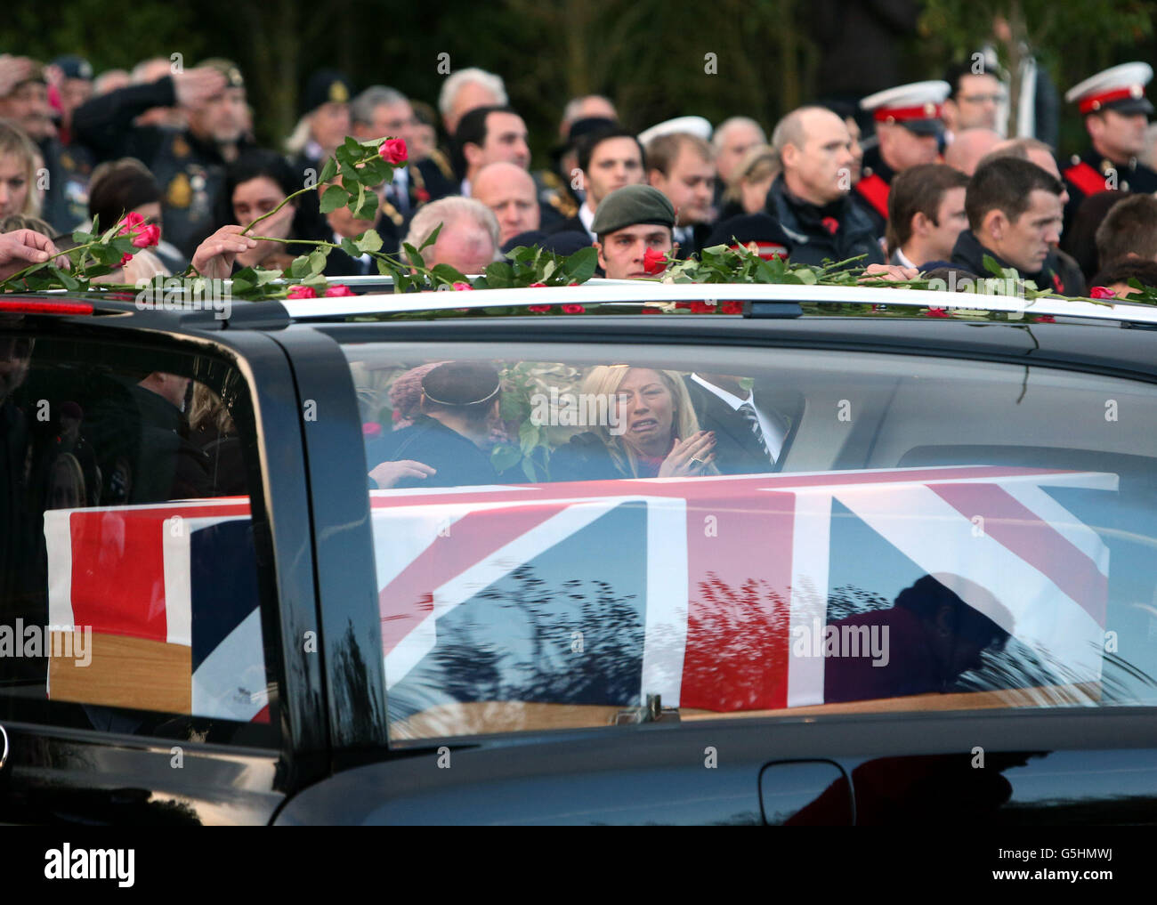 Mourners lay flowers on the hearse carrying Corporal Channing Day from ...