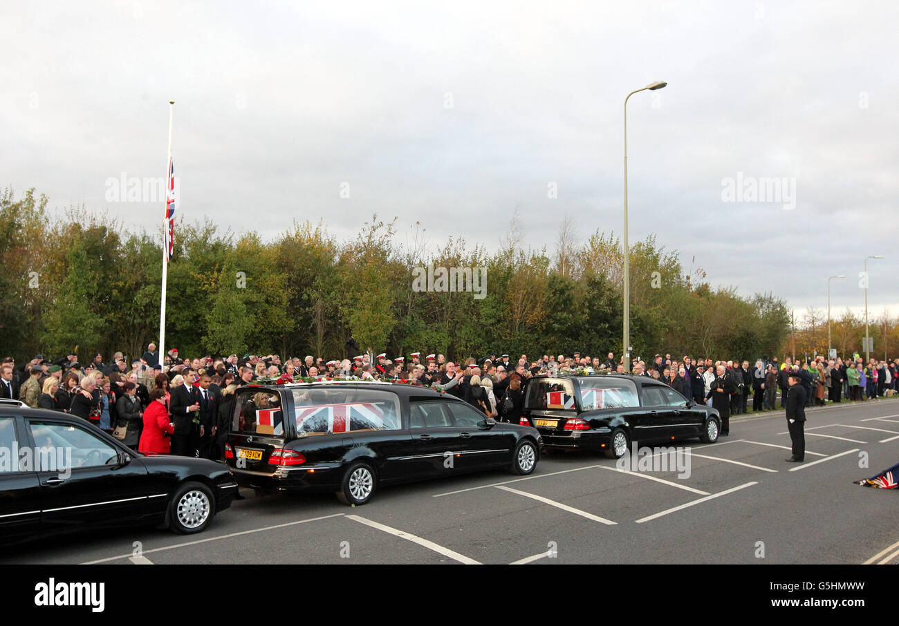 Mourners lay flowers on the hearses carrying the bodies of Corporal ...