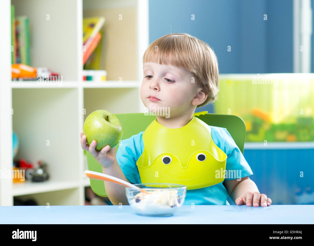 child eating apple at dinner in nursery at home Stock Photo - Alamy