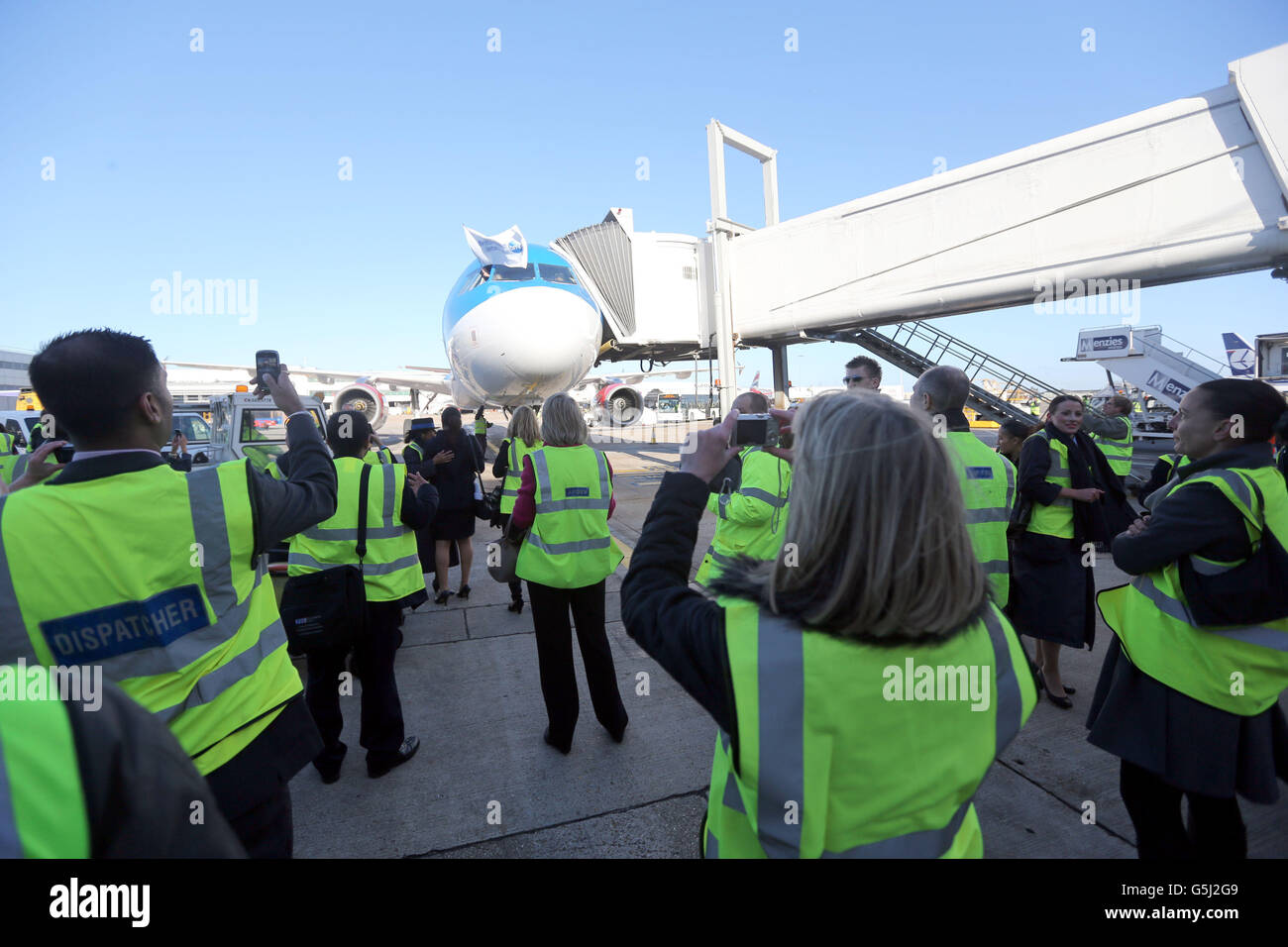 Staff take pictures as the last BMI flight lands at Heathrow Airport ...
