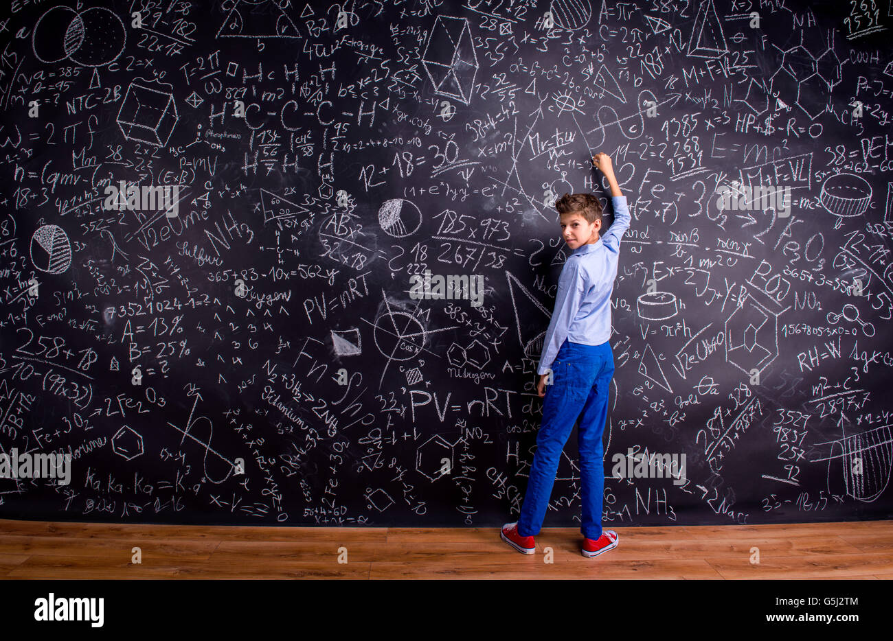 Boy against big blackboard with mathematical symbols and formula Stock ...