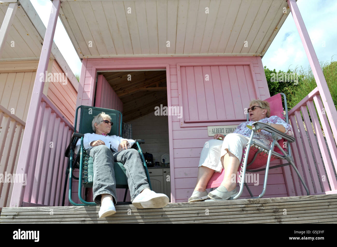 Two ladies relax in their beach hut as they enjoy the sunny weather at ...