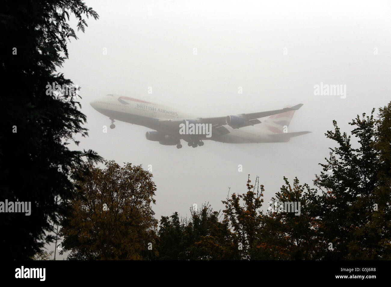 A plane lands in the fog at Heathrow Airport as early-morning fog ...