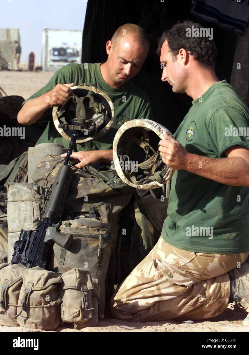 Royal Marine Eric Lowe from Plymouth cleans the sand off his BV206 as ...