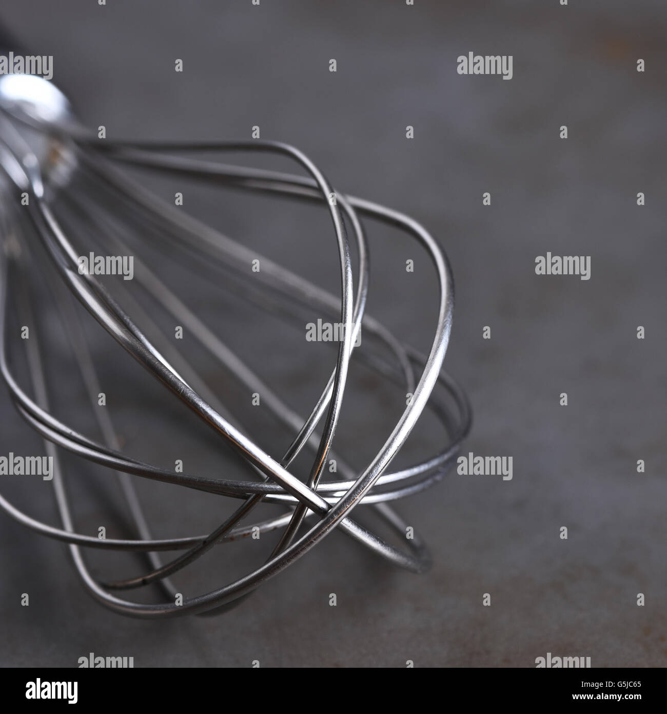 Closeup of a kitchen whisk on a metal surface, with shallow depth of ...