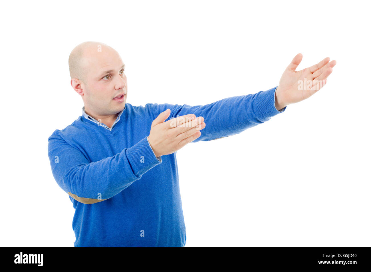 friendly young man pointing to his side and looking into the camera ...