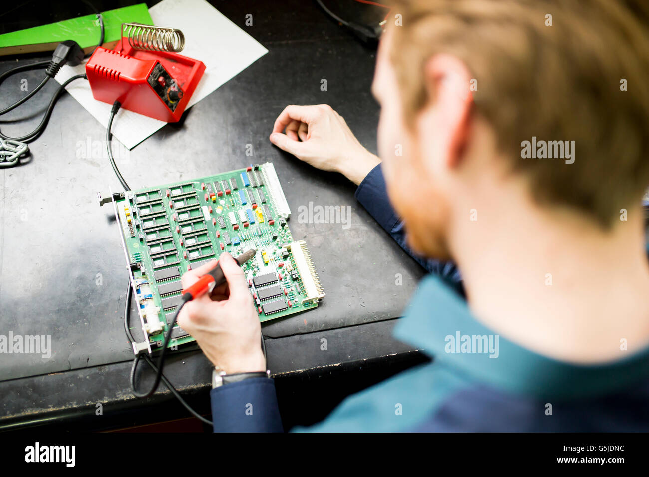 Young man working in electronics workshop Stock Photo - Alamy