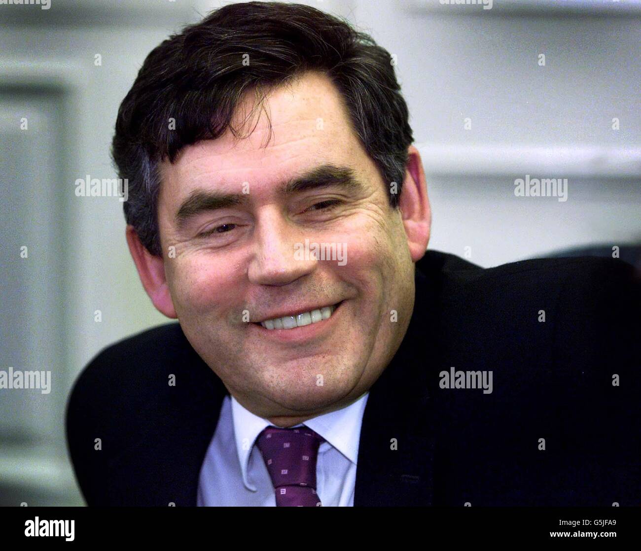 Britain's Chancellor of the Exchequer Gordon Brown smiles as he sits in ...