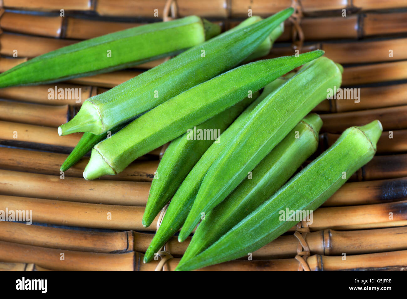 A heap of raw okra or Lady's fingers or gumbo on bamboo background ...