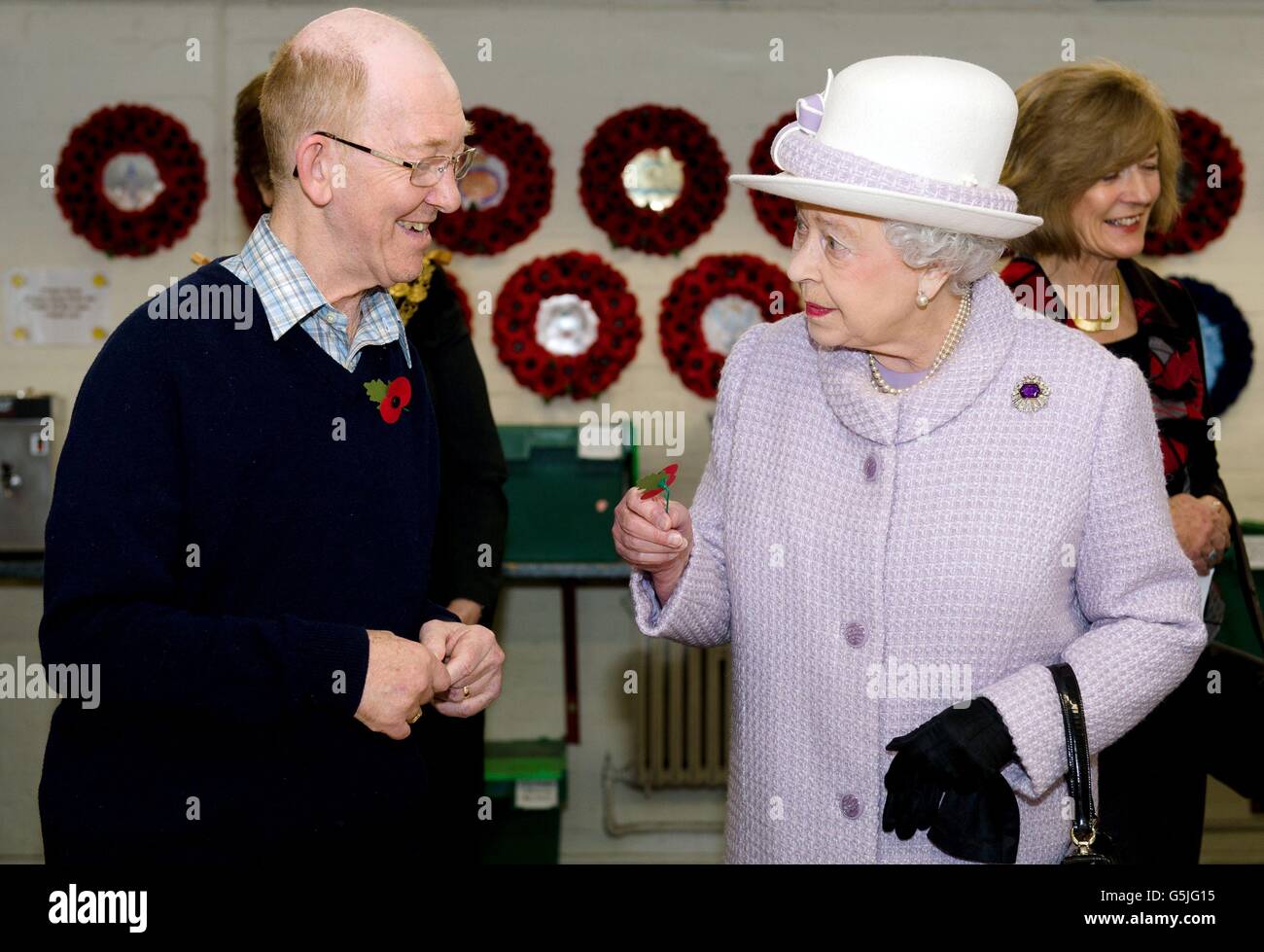 Queen Elizabeth II makes her own poppy at The Poppy Factory as see ...