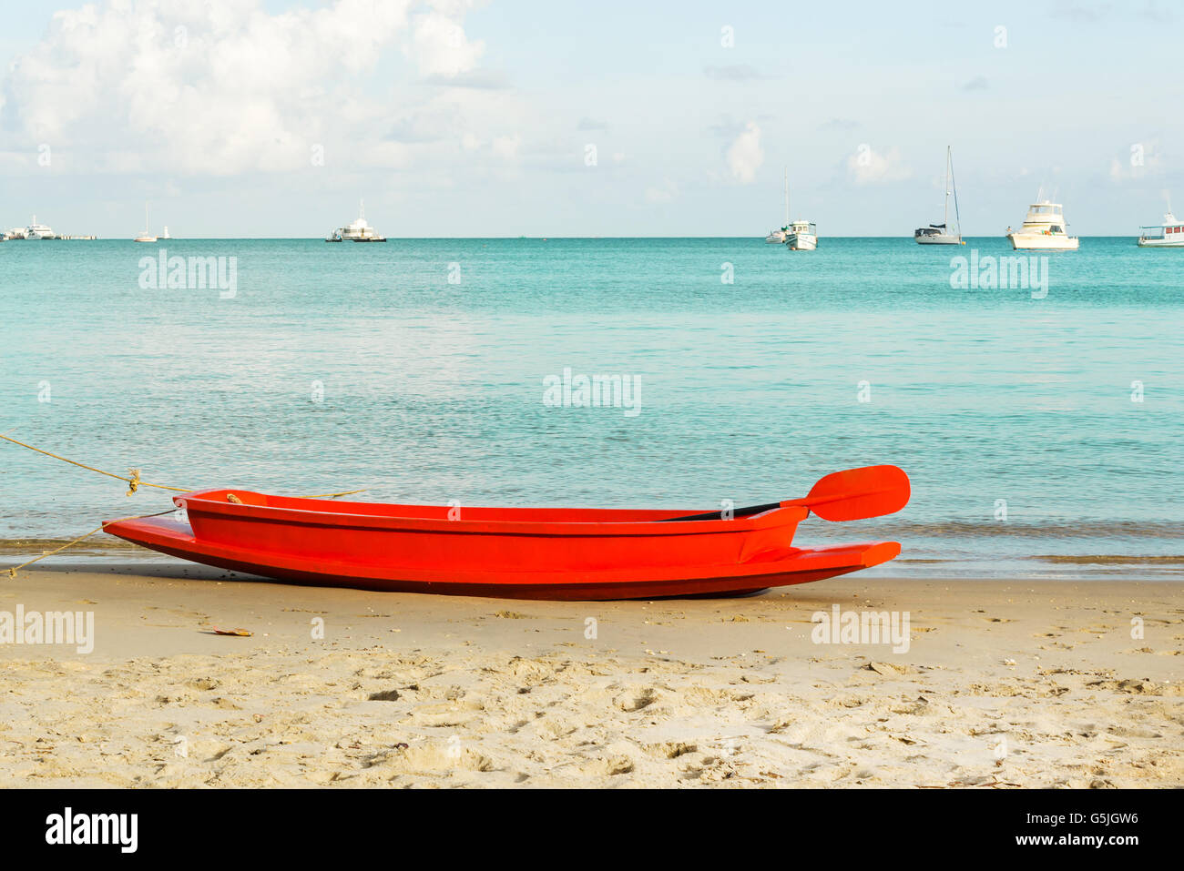 Orange boat on the sand beach with blue sea and sky background in ...