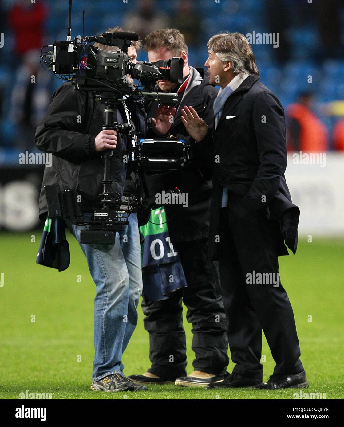 Manchester City manager Roberto Mancini (right) is filmed by a TV ...