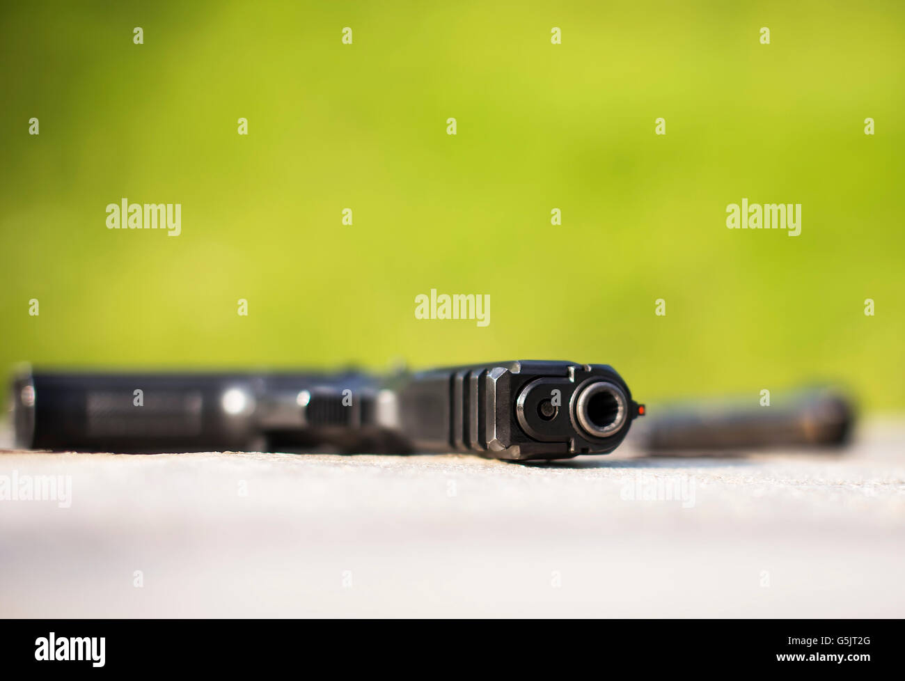 Front side of a gun with a blurred background Stock Photo - Alamy
