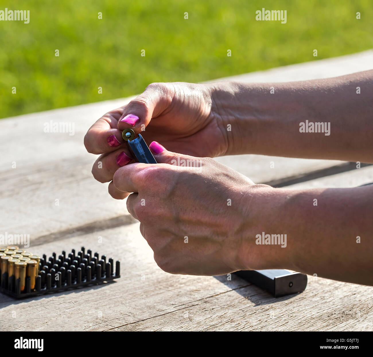 Woman is loading a clip with a bullet Stock Photo - Alamy